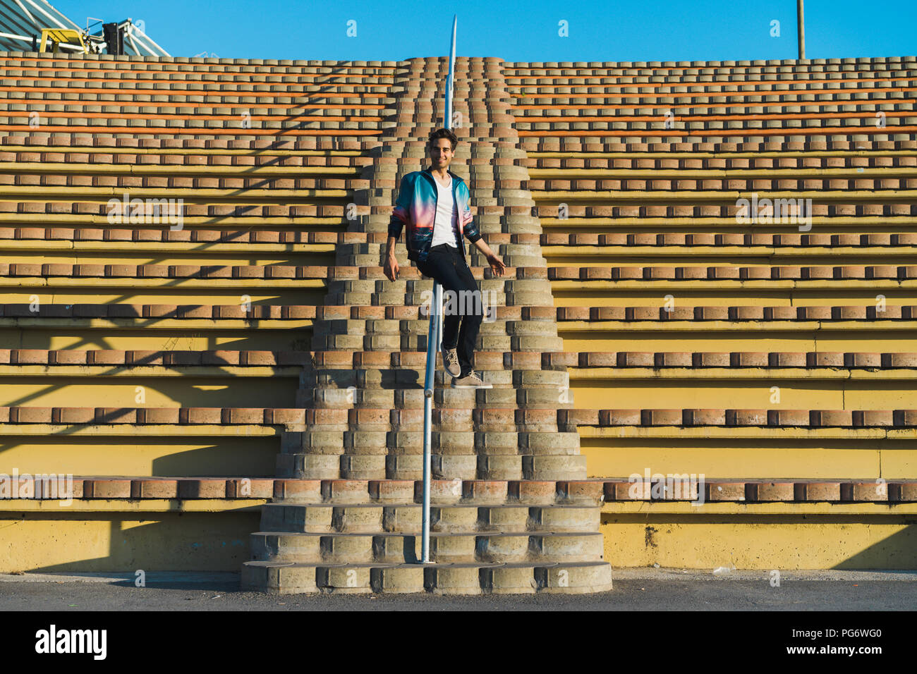 Man sliding on railing of a grandstand Stock Photo - Alamy