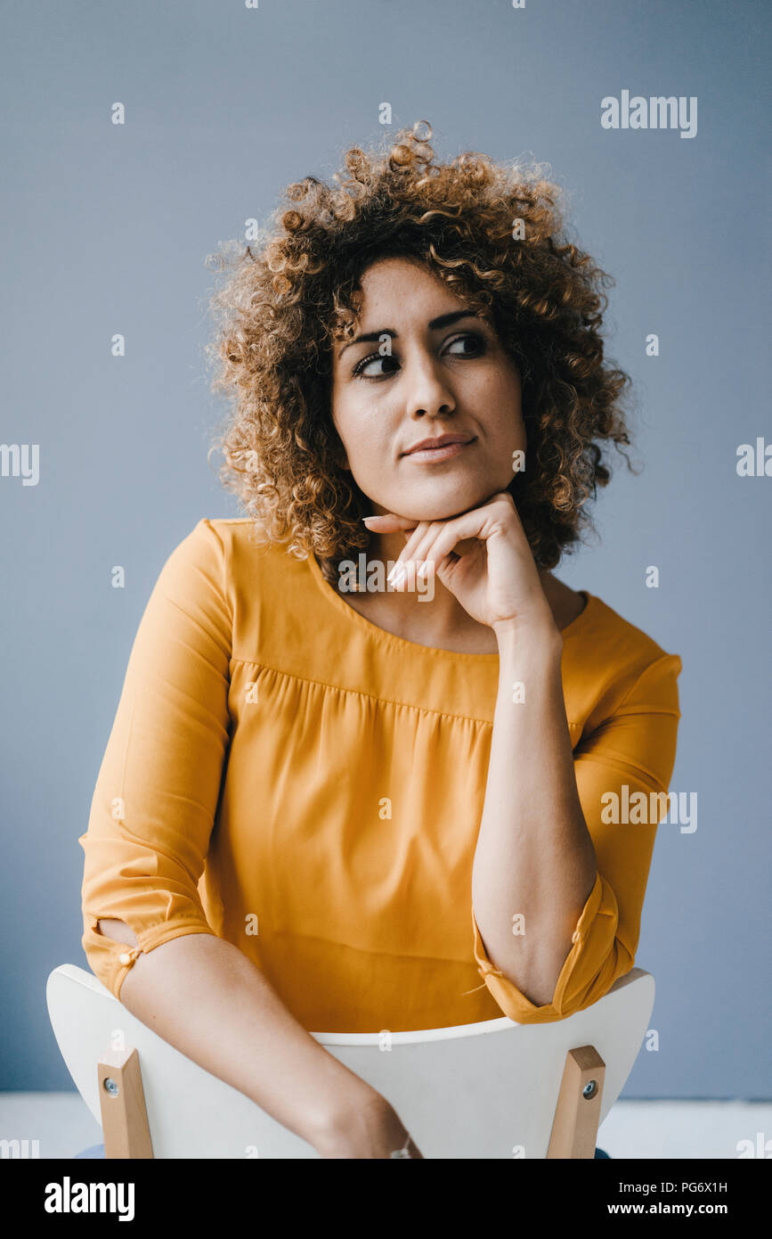 Woman sitting on chair, thinking Stock Photo - Alamy