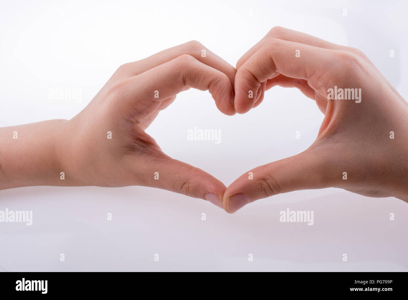 Hand making a heart shape on a white background Stock Photo - Alamy