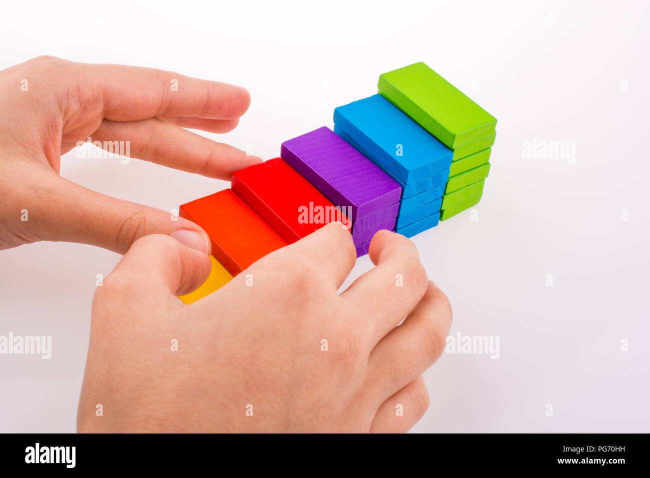 Hand playing with colored domino on white background Stock Photo - Alamy
