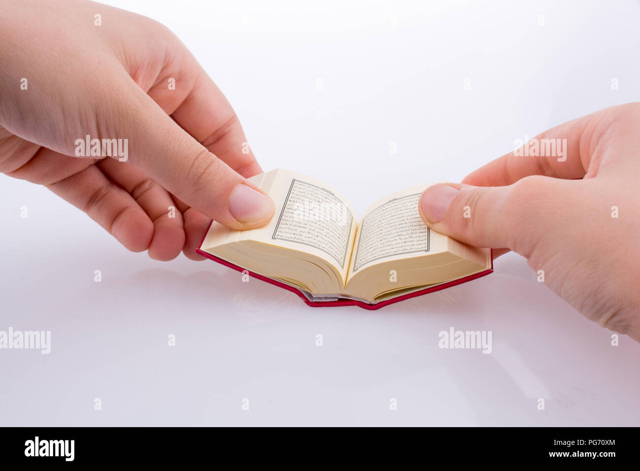 Hand holding The Holy Quran on a white background Stock Photo - Alamy