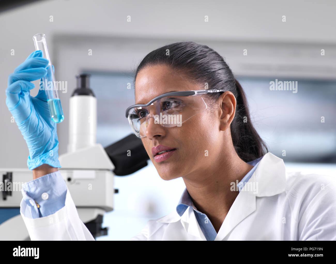 Biotechnology Research, female scientist mixing a chemical formula ...