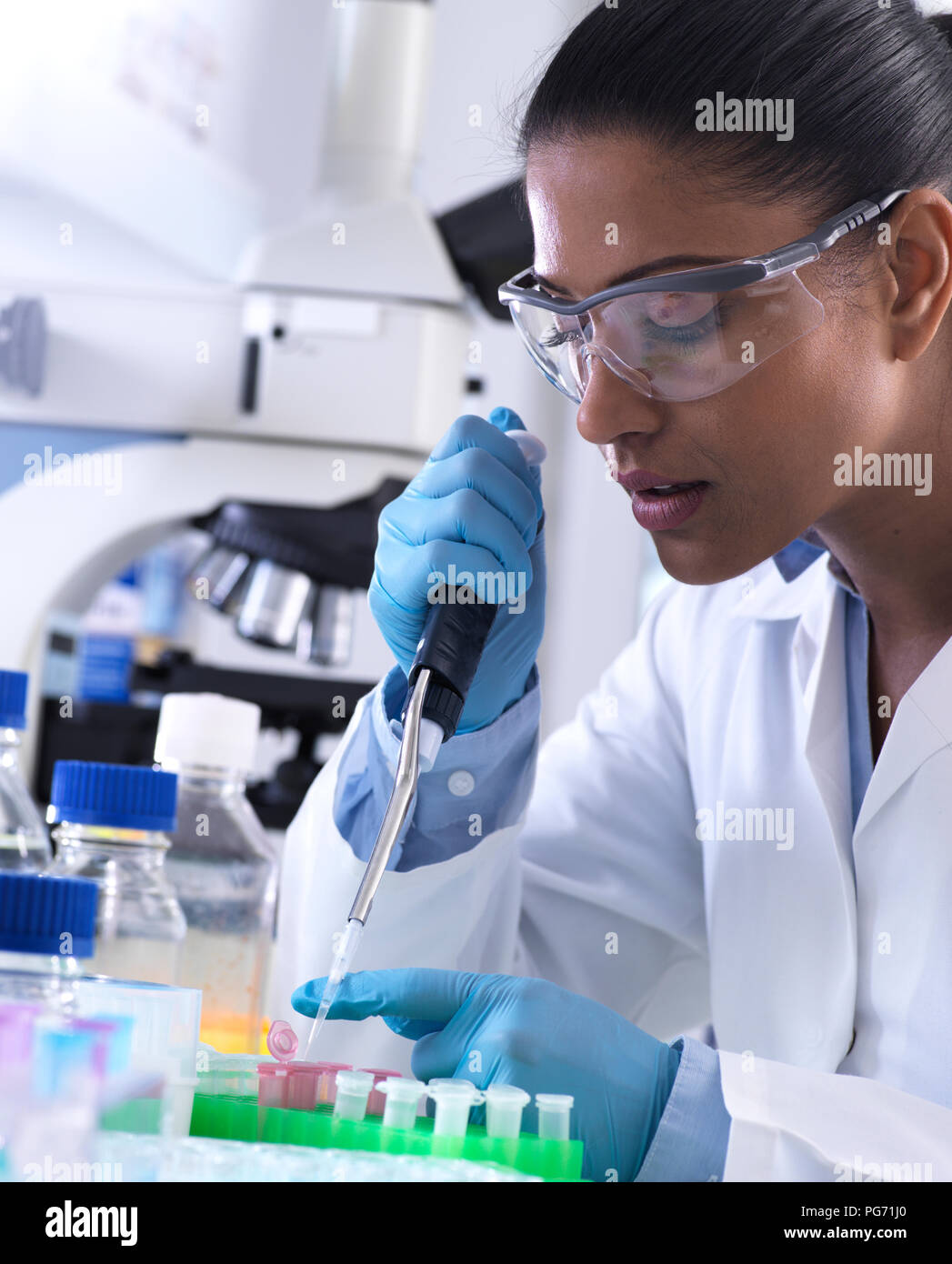 Genetic research, female scientist pipetting DNA or chemical sample ...