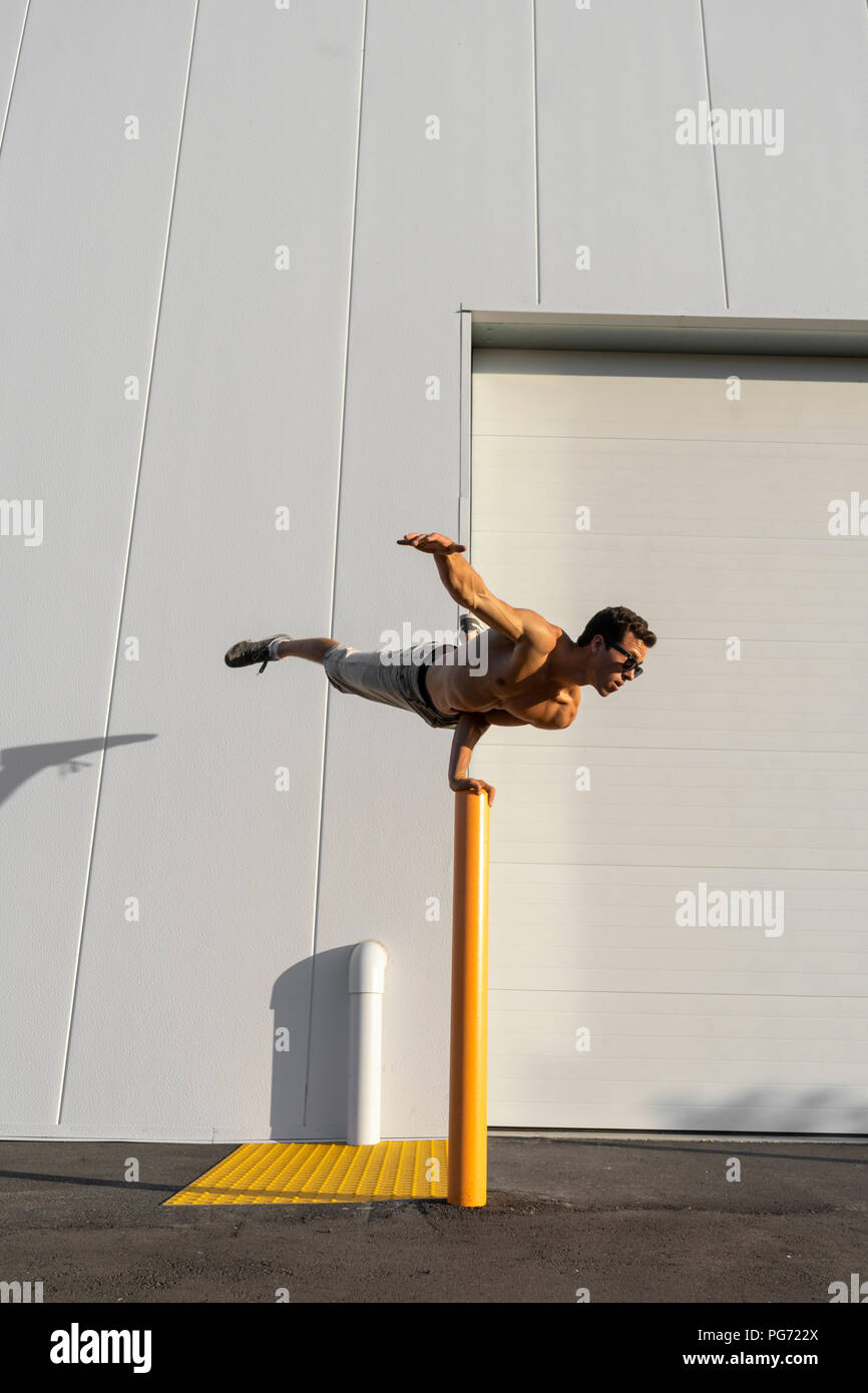 Acrobat training on a pole Stock Photo - Alamy