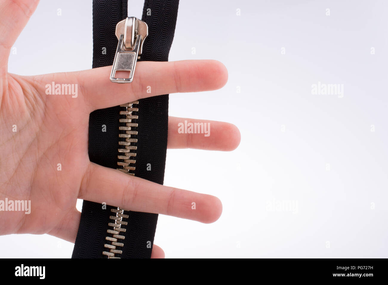 Hand holding color zipper on a white background Stock Photo - Alamy
