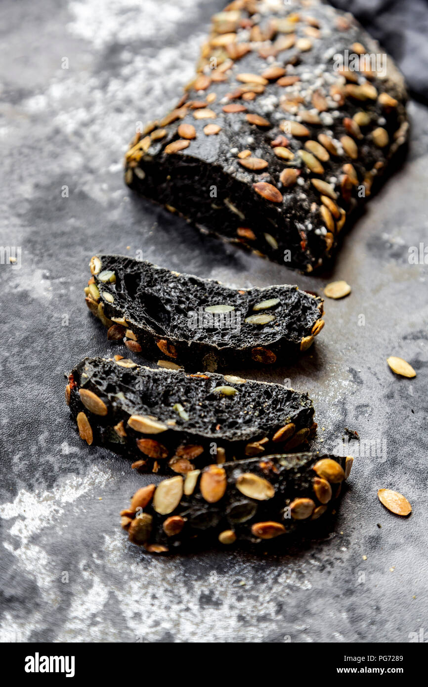 Black sepia spelt bread with pumpkin seeds Stock Photo - Alamy