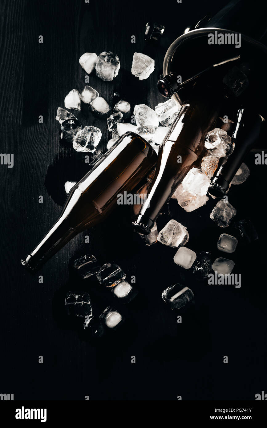 flat lay with bucket, glass bottles of beer and ice cubes arranged on ...