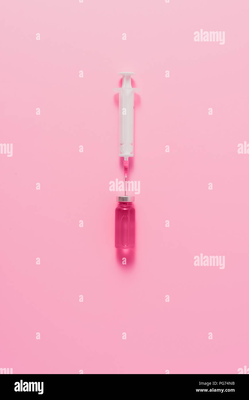 top view of syringe with ampule of pink liquid on pink surface Stock ...