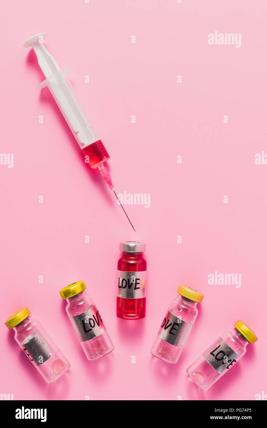 top view of syringe and bottles with love vaccine signs on pink Stock ...