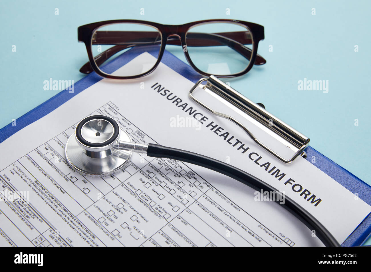 insurance health claim form, clipboard, eyeglasses and stethoscope on ...