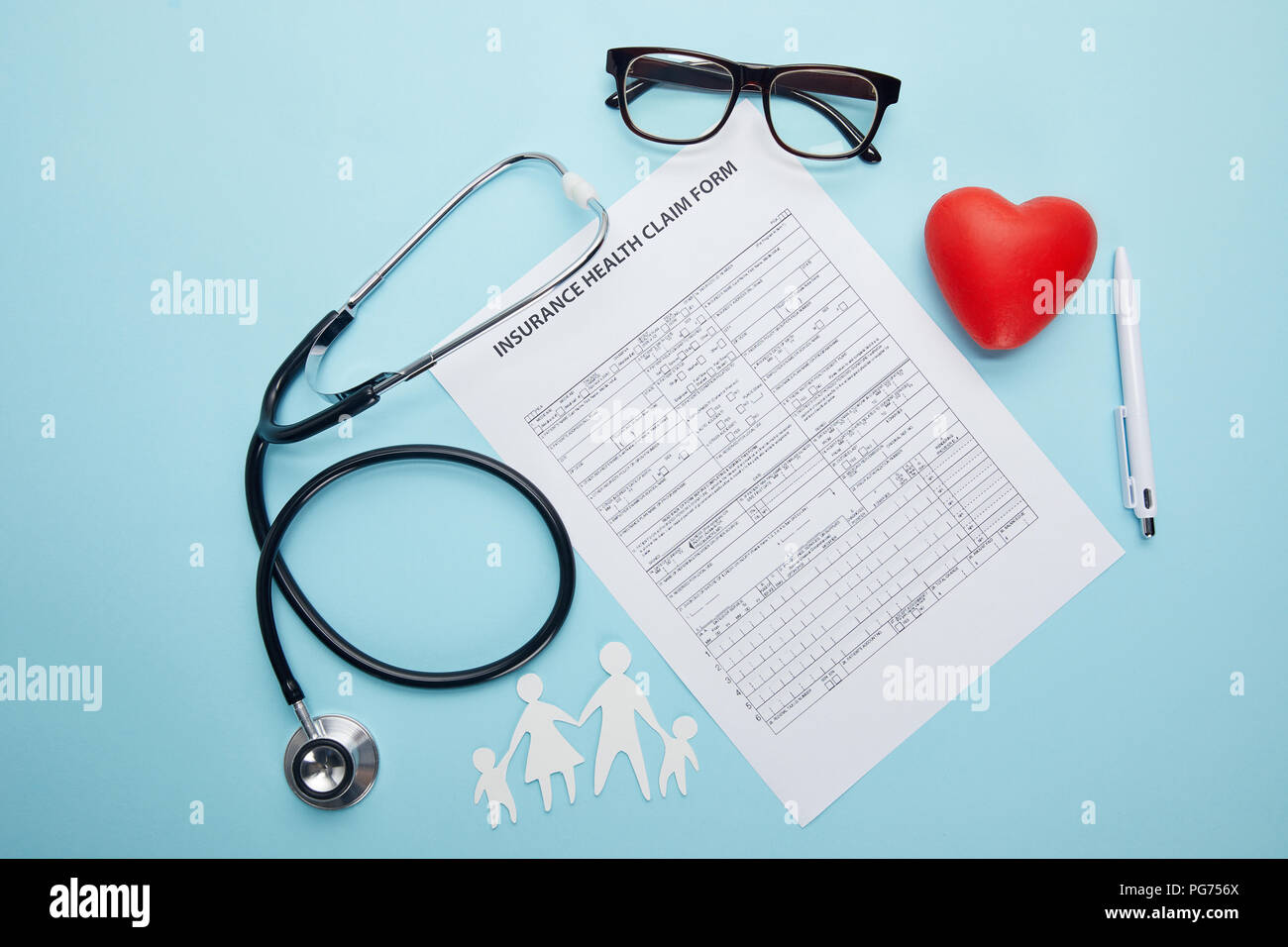 top view of insurance health claim form, eyeglasses, paper cut family ...