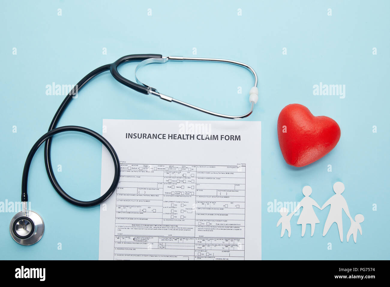 top view of insurance health claim form, paper cut family, red heart ...