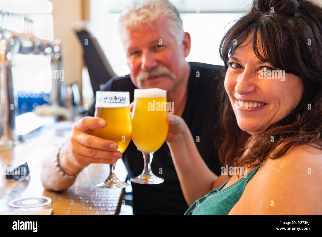 Attractive Middle-Aged Couple Toasting Glasses of Micro Brew Beer At ...