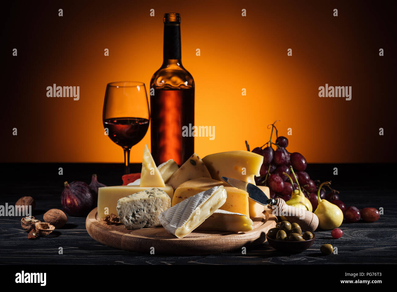 different types of cheeses and alcohol drink on table on orange Stock ...
