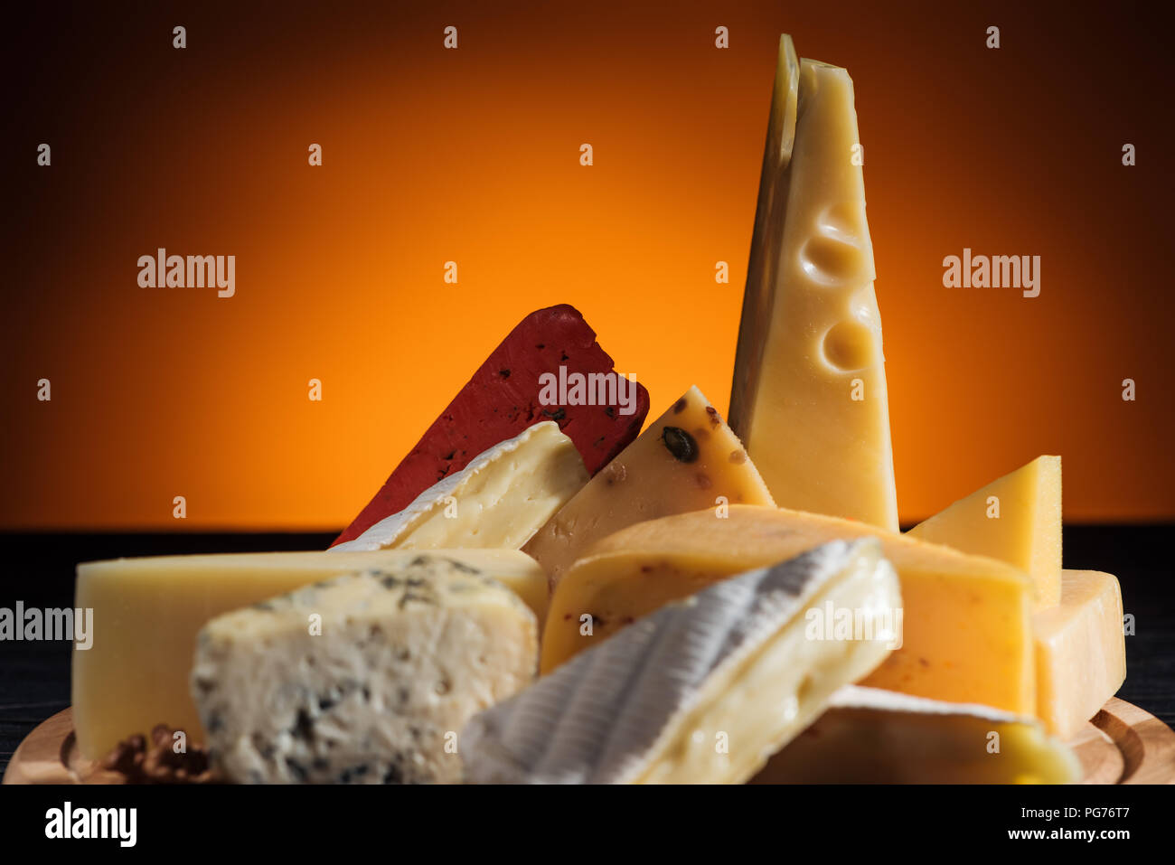 different types of tasty cheeses on orange Stock Photo - Alamy