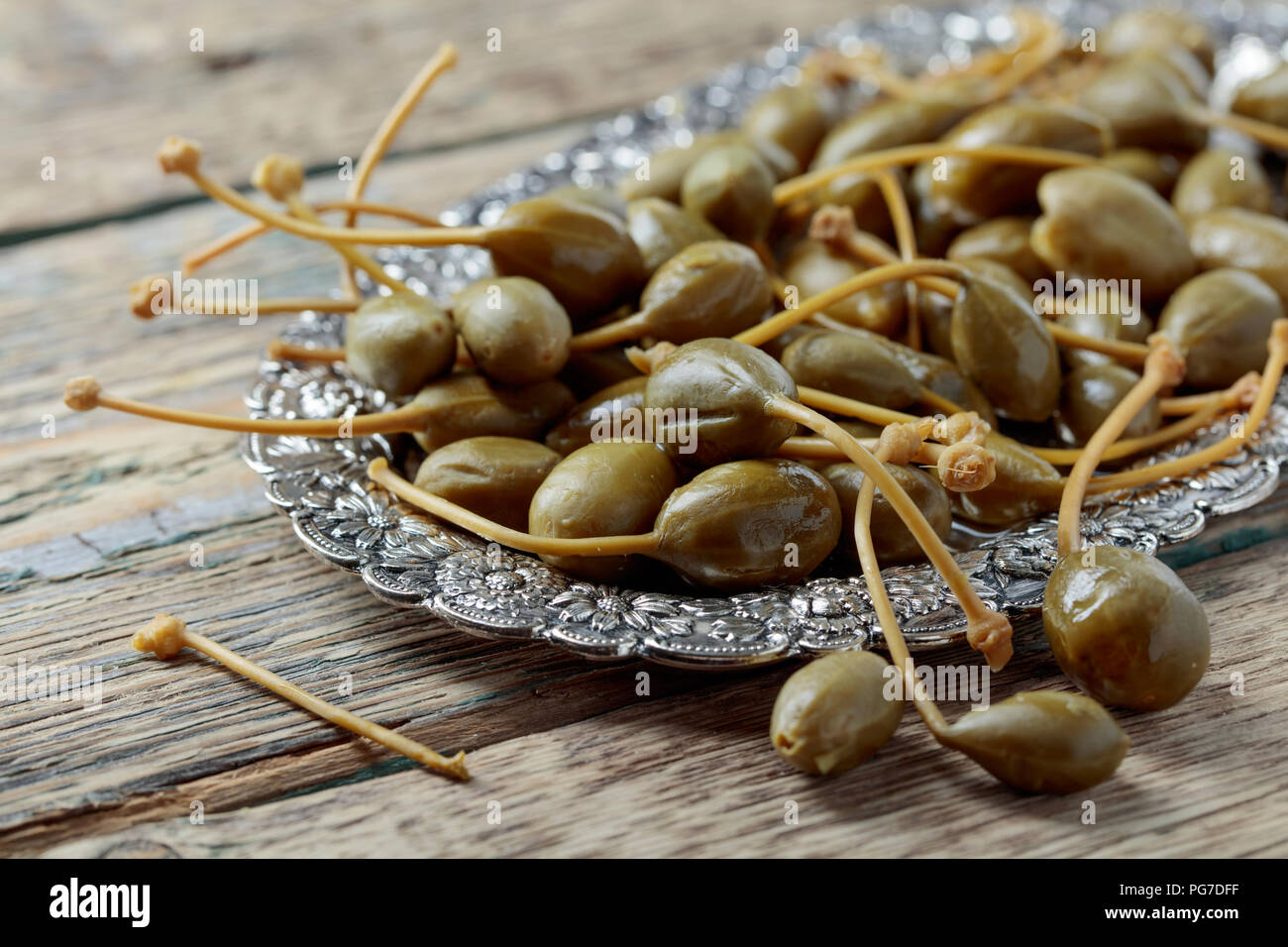 Pickled caper berries in metal dish . Edible fruits of Capparis ...