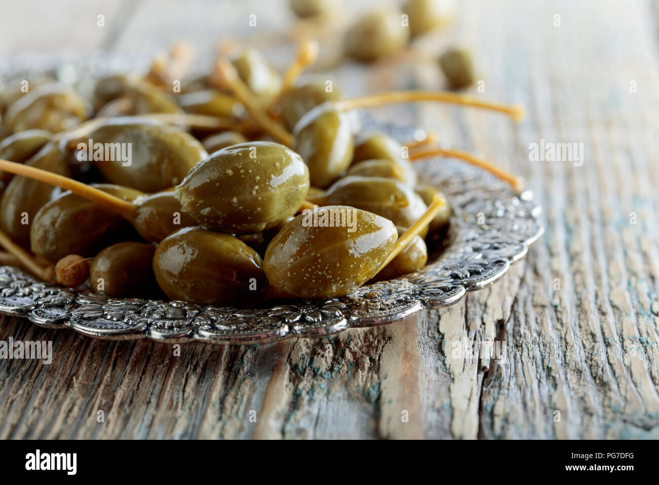 Pickled caper berries in metal dish . Edible fruits of Capparis ...