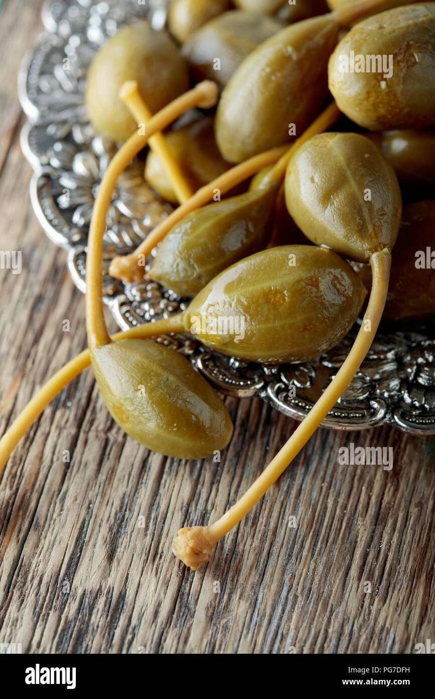 Pickled caper berries in metal dish . Edible fruits of Capparis ...