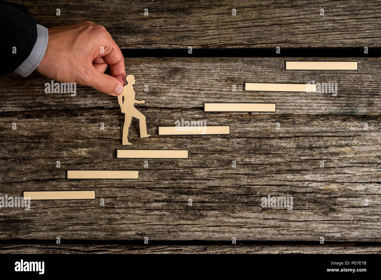 Businessman climbing the steps to success in a conceptual image with ...