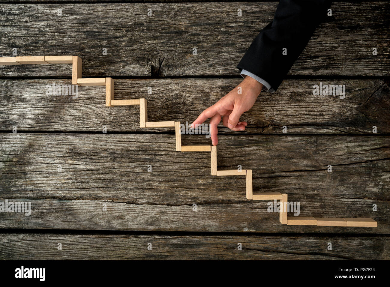 Businessman or student walking his fingers up wooden steps resembling a ...