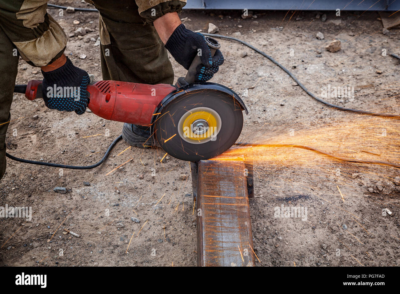 Close up of a young man welder in brown uniform, welders leathers ...