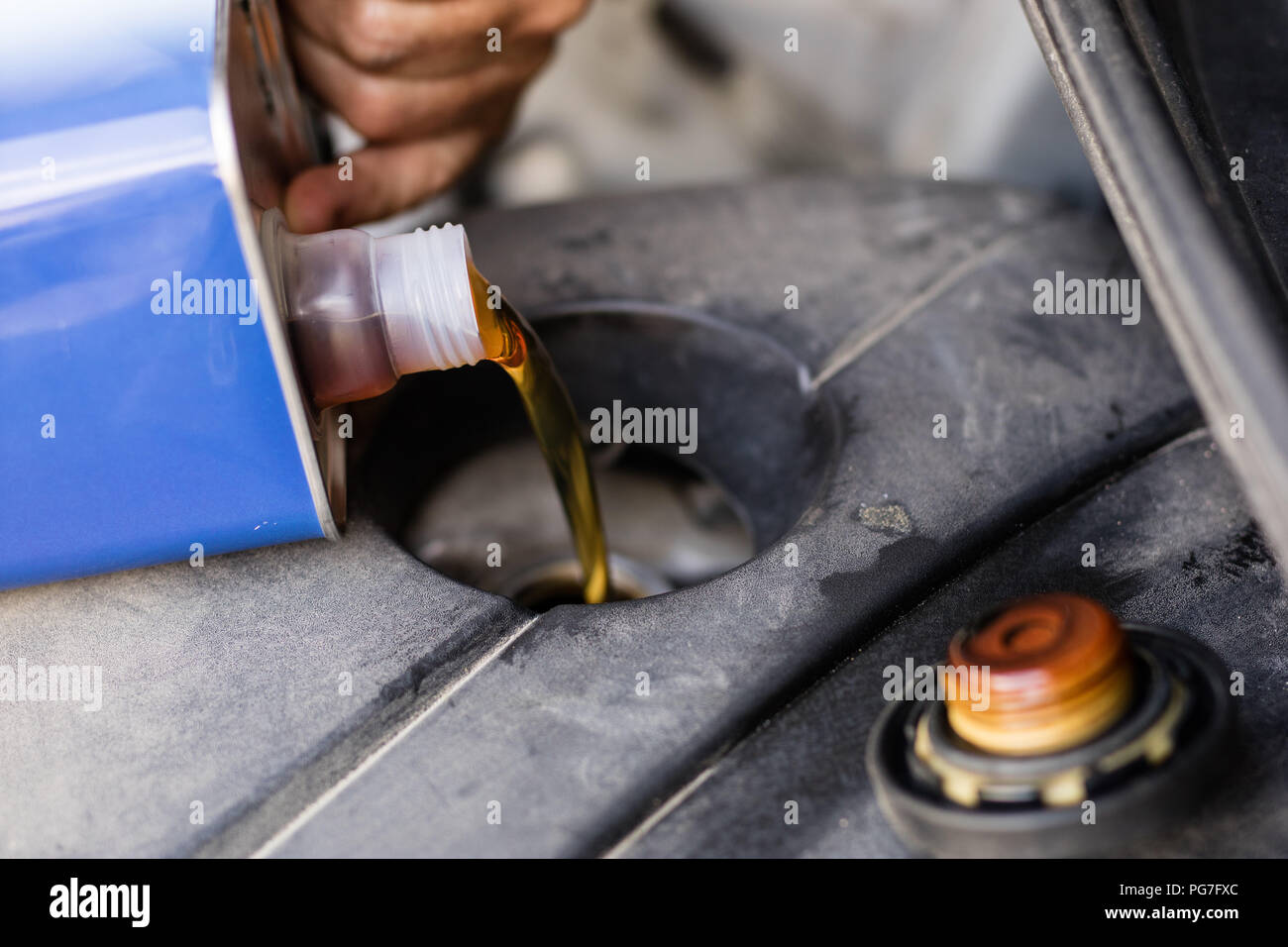 Pouring oil to the car engine. Supplementing liquids in the drive unit ...