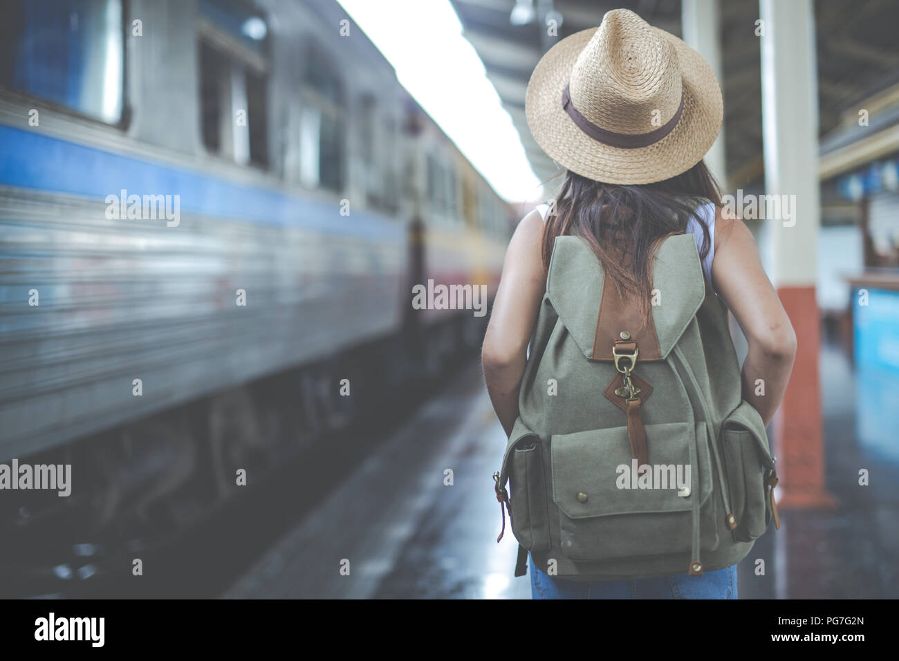 Traveler girl with a backpack traveling to the train station. Travel ...