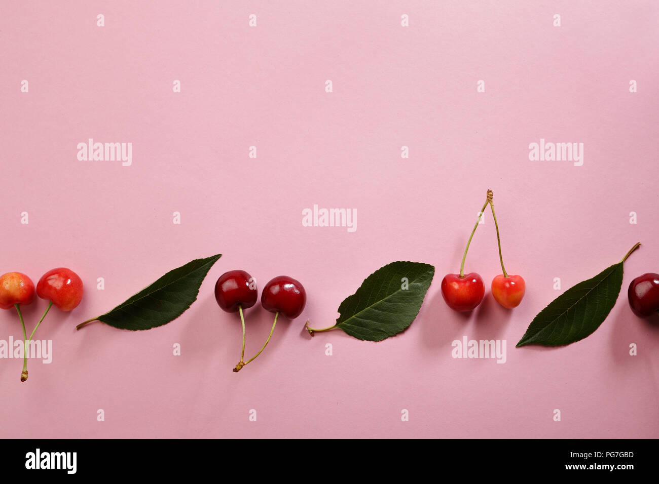 Pink background with cherry Stock Photo - Alamy