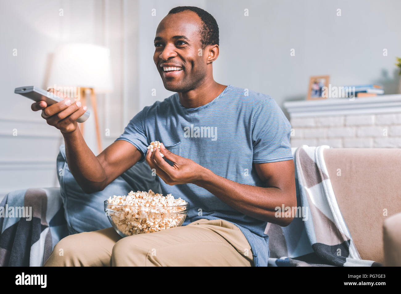 High-spirited man eating pop corn Stock Photo - Alamy