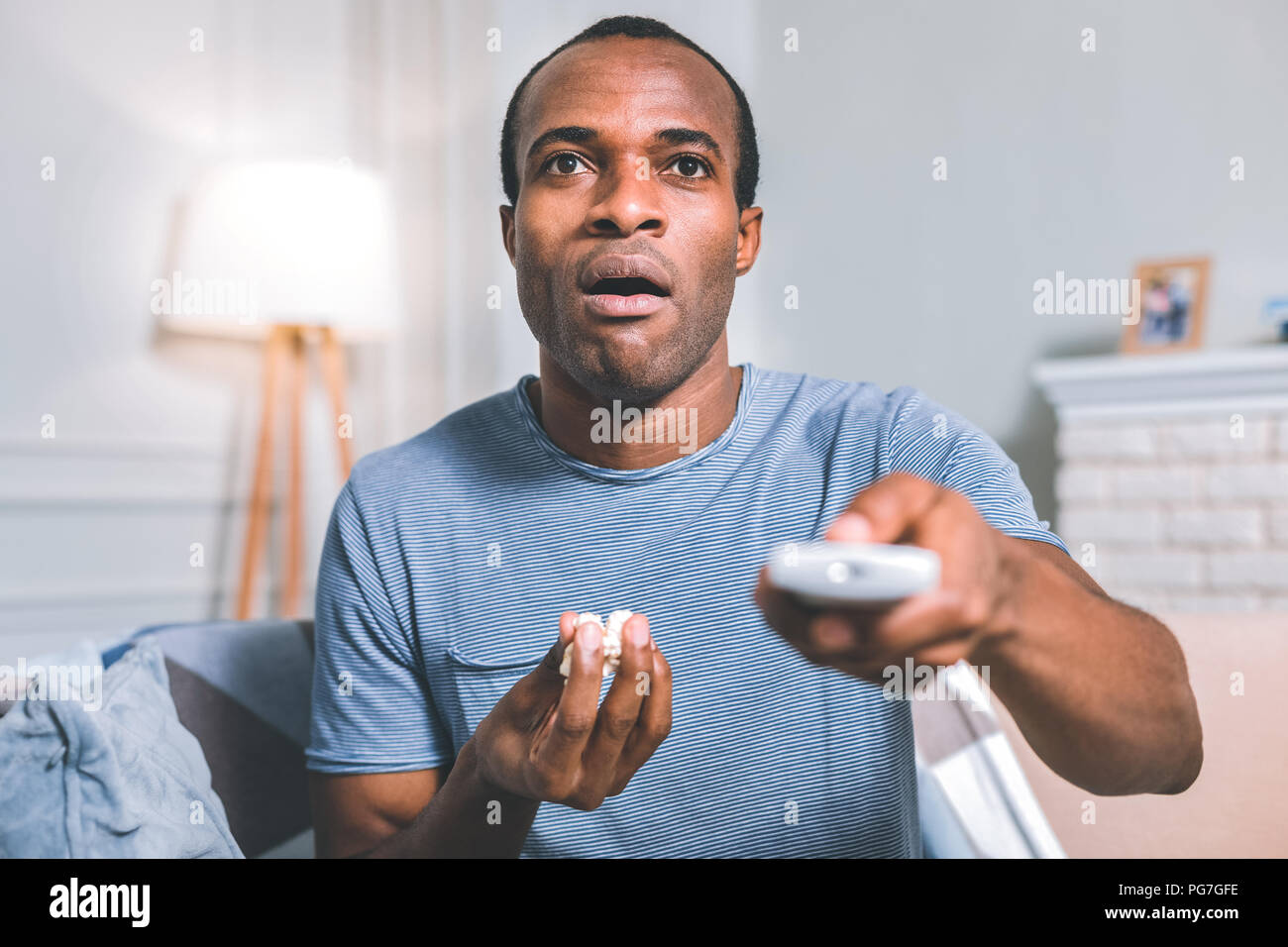 Surprised man watching a movie Stock Photo - Alamy