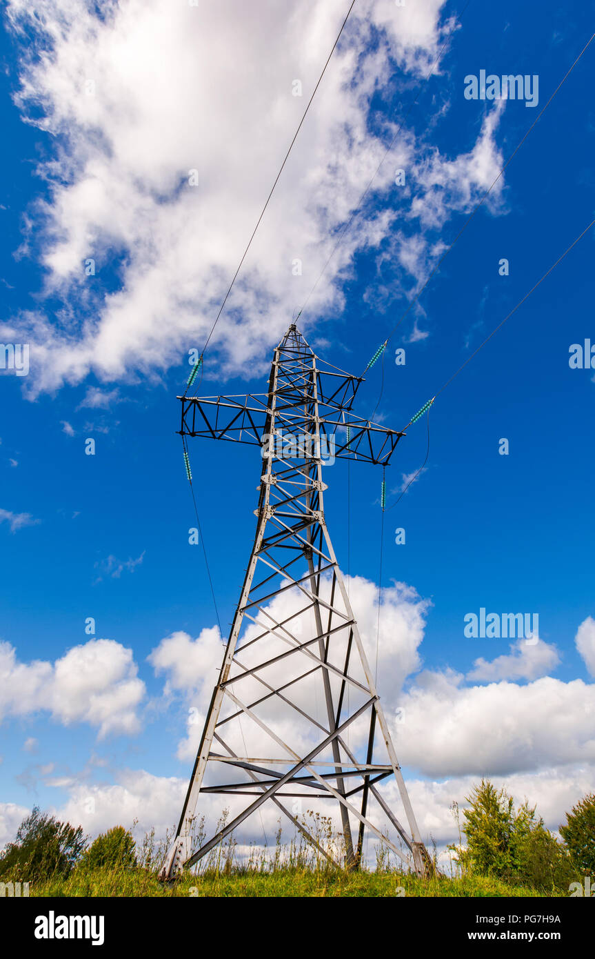 power line tower on the hill. view from below. beautiful blue sky with ...