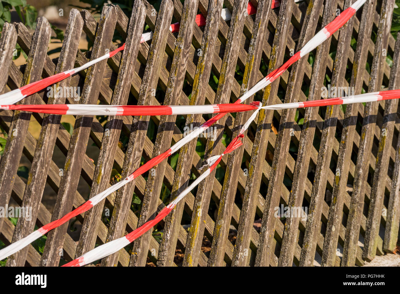Red and white ribbon barriers at the wooden fence Stock Photo - Alamy
