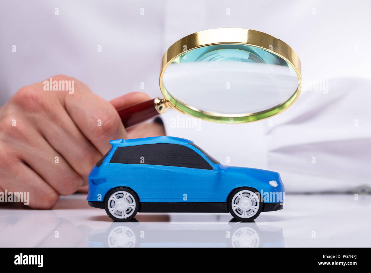 Businessman's Hand Holding Magnifying Glass Over Small Blue Car Stock ...