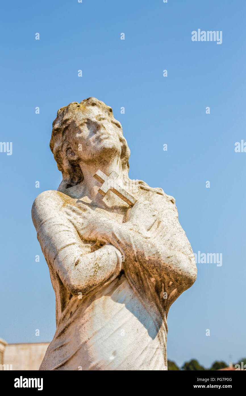 details of statue of woman hugging Cross on chest Stock Photo - Alamy