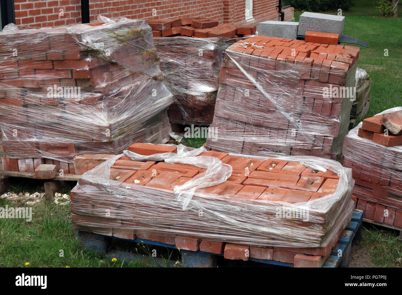 new reclaimed hand made red bricks on site Stock Photo - Alamy