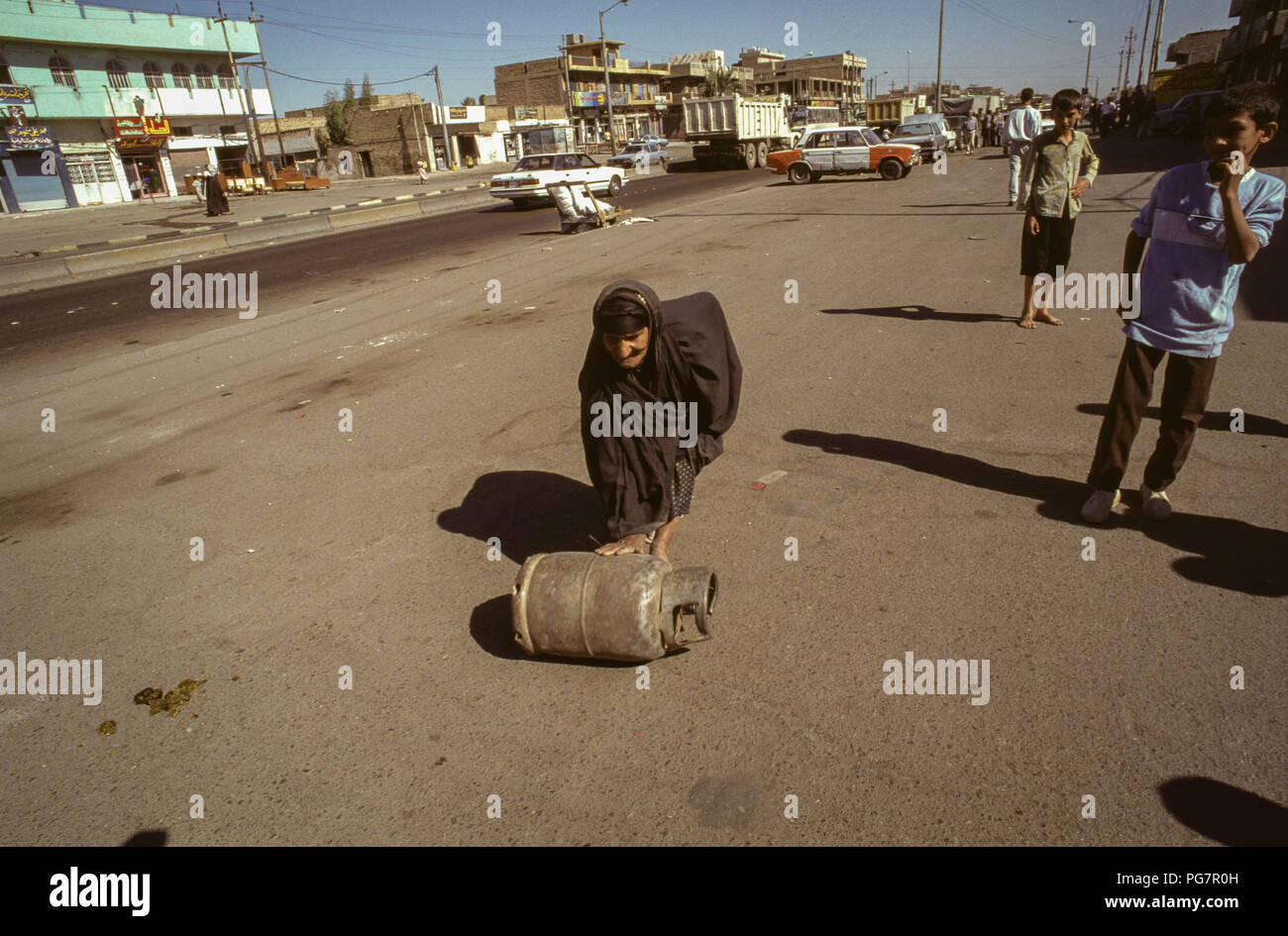 Baghdad, Iraq - October 1995 - An elderly Iraqi woman rolls a butane ...