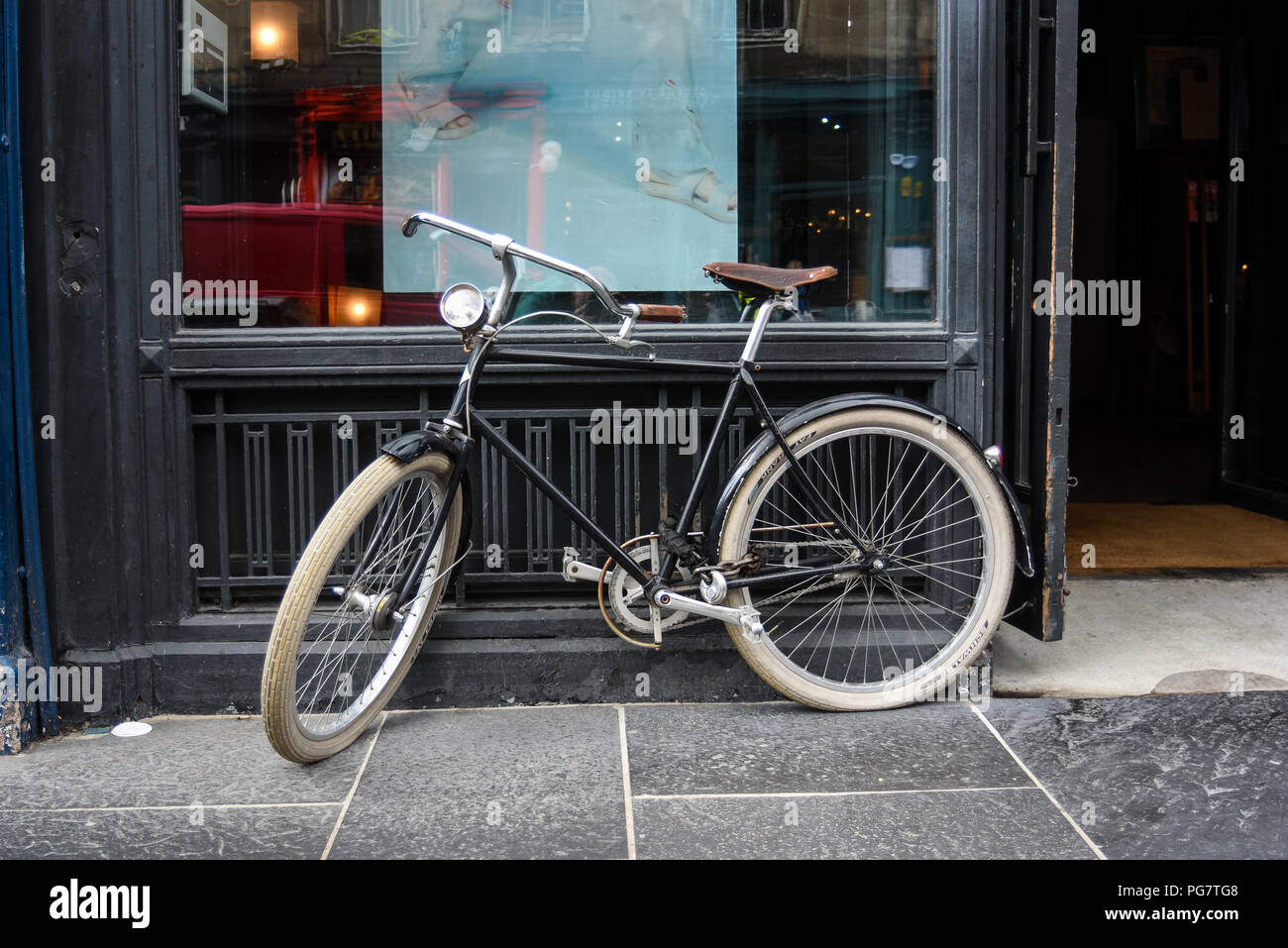 bike parked at the door of a store in the city of Edinburgh, Scotland ...