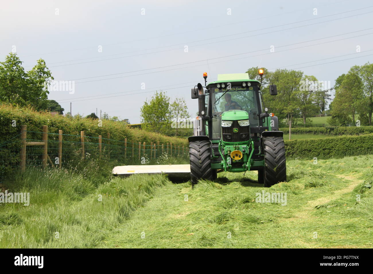 John Deere tractor mowing with single offset mower Stock Photo - Alamy