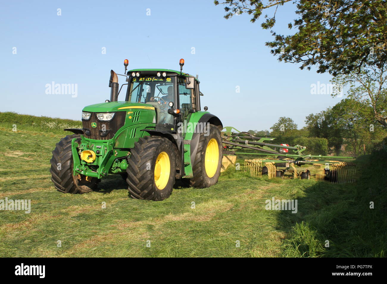John Deere tractor raking silage with a Krone rake Stock Photo - Alamy