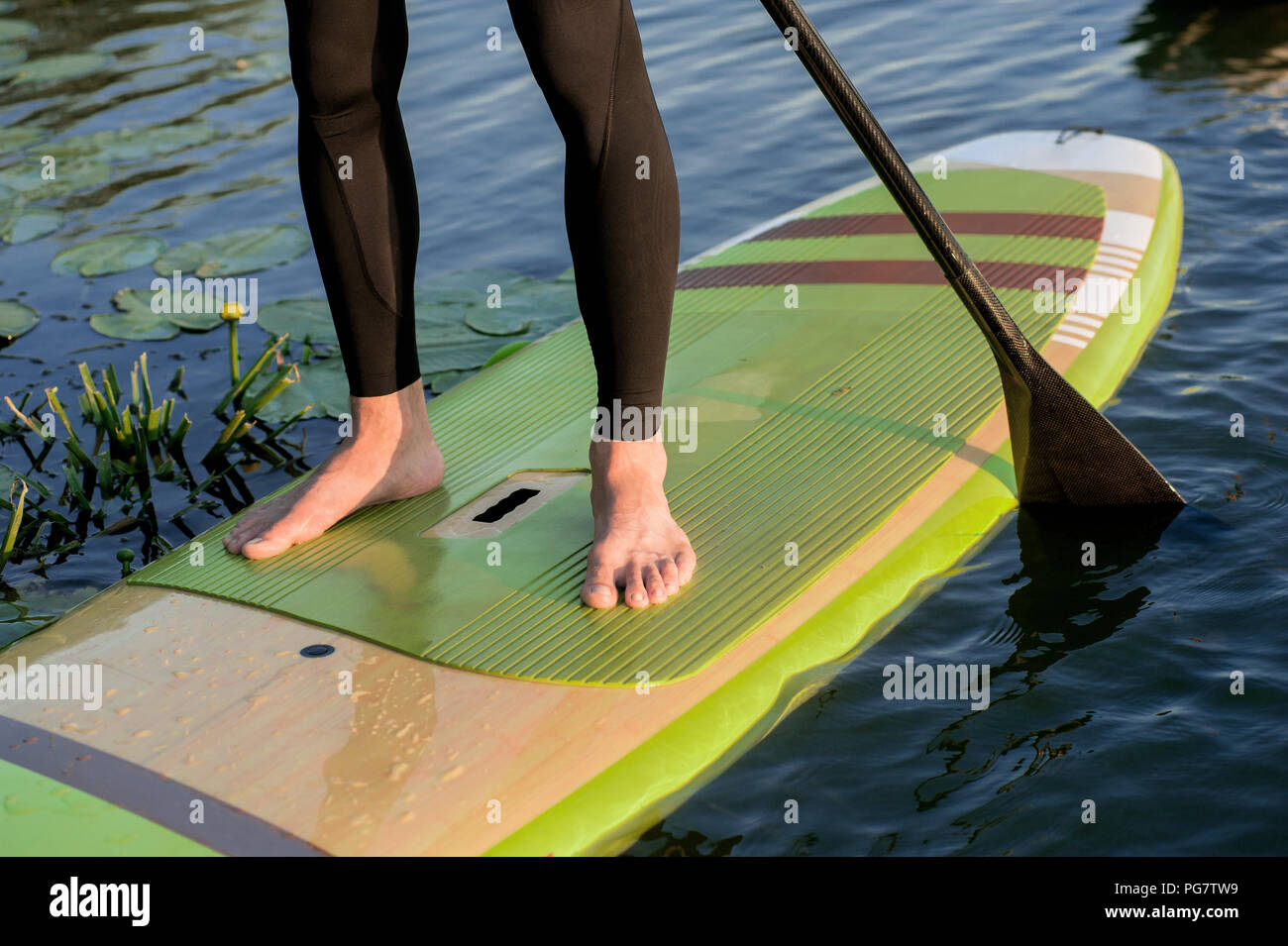 SUP confident man swimsuit standing with a paddle on the surfboard ...