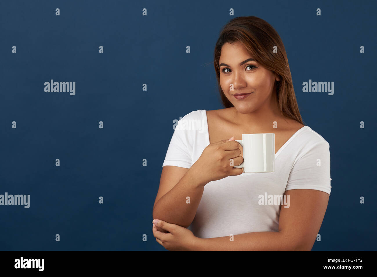 Lady hold hot tea cup isolated on blue studio background Stock Photo ...