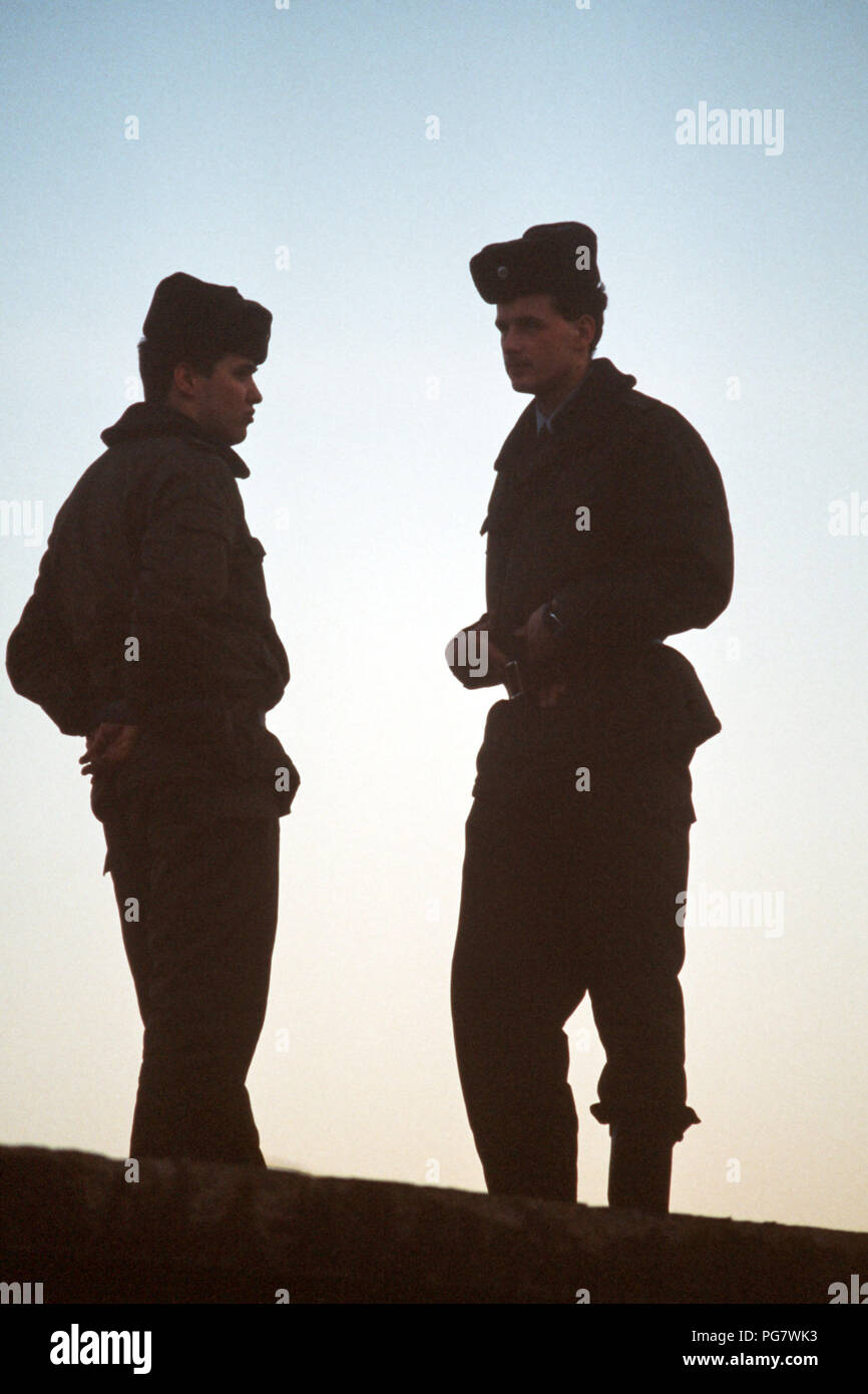 Berlin Wall 1989 - East German guards stand atop the Berlin Wall beside ...