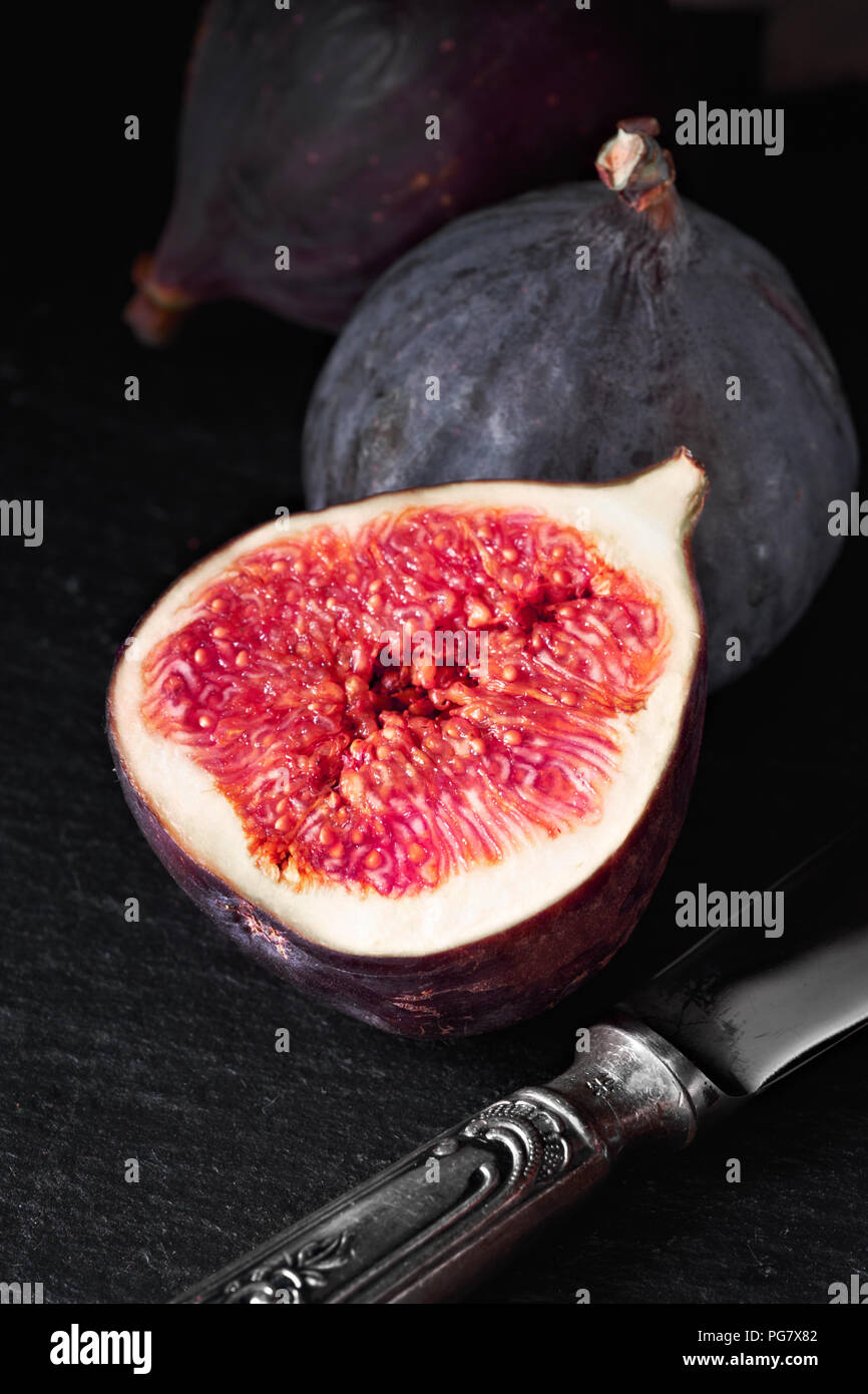Close-up on fresh figs on dark slate stone, side view Stock Photo - Alamy