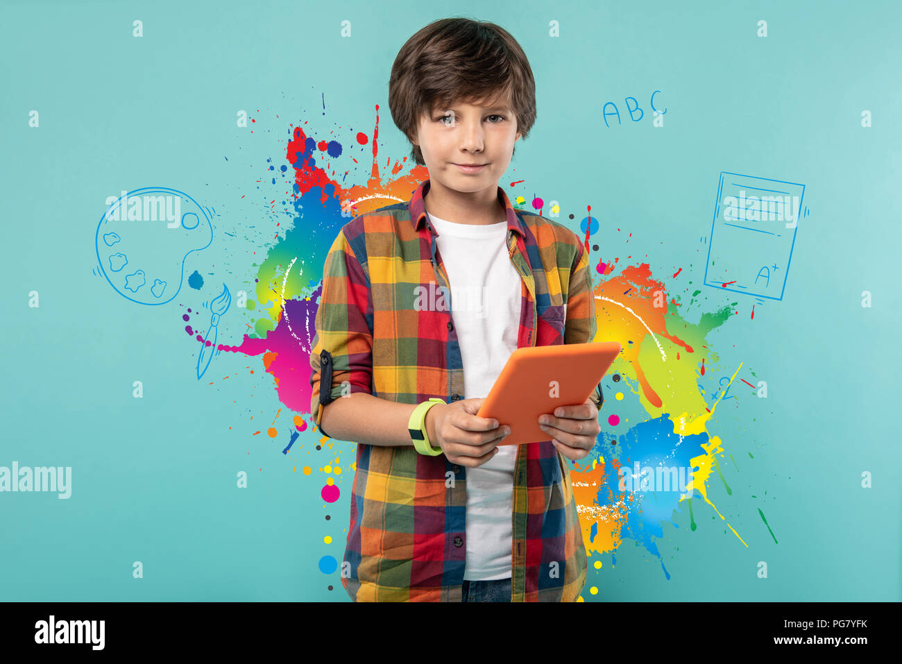 Creative boy smiling and using his modern tablet for drawing Stock ...