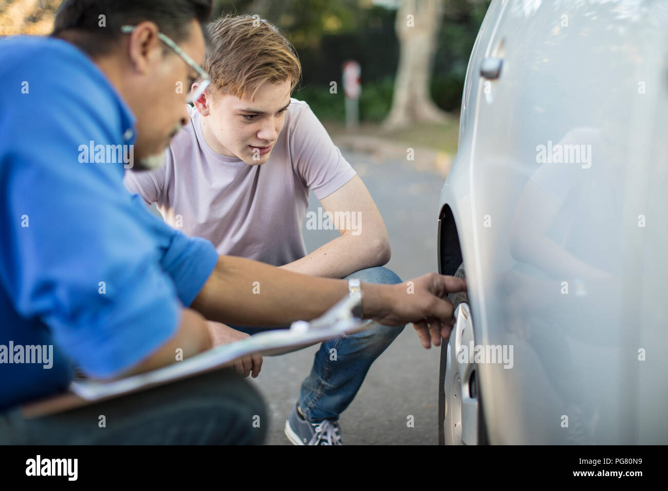Learner driver instructor checking tyre car hi-res stock photography ...