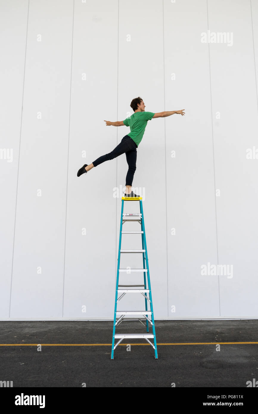 Acrobat balancing on ladder Stock Photo - Alamy