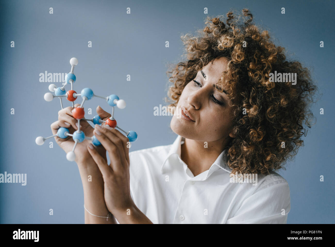 Female scientist looking at molecule model, looking for solutions Stock ...