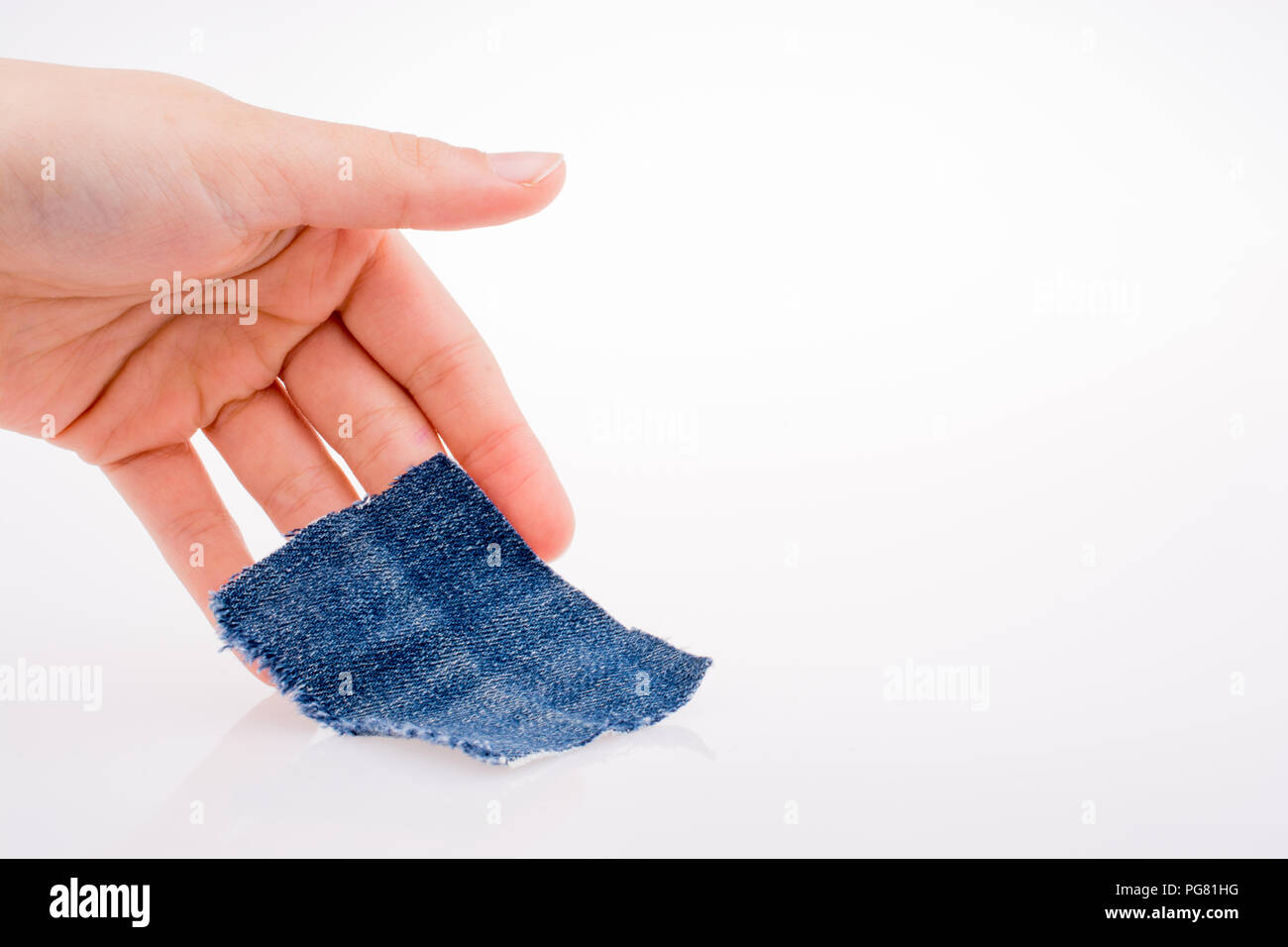 Hand holding a denim fabric piece on white background Stock Photo - Alamy