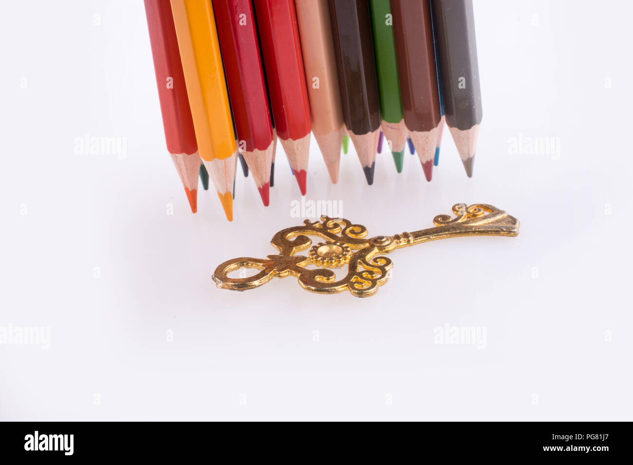 color pencils of various colors near a key on a white background Stock ...