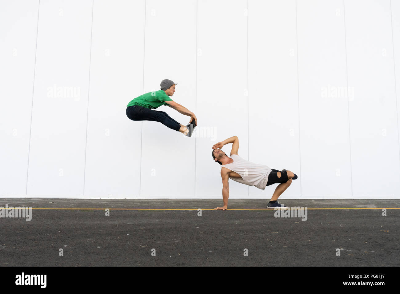 Two acrobats doing tricks together, jumping mid-air Stock Photo - Alamy